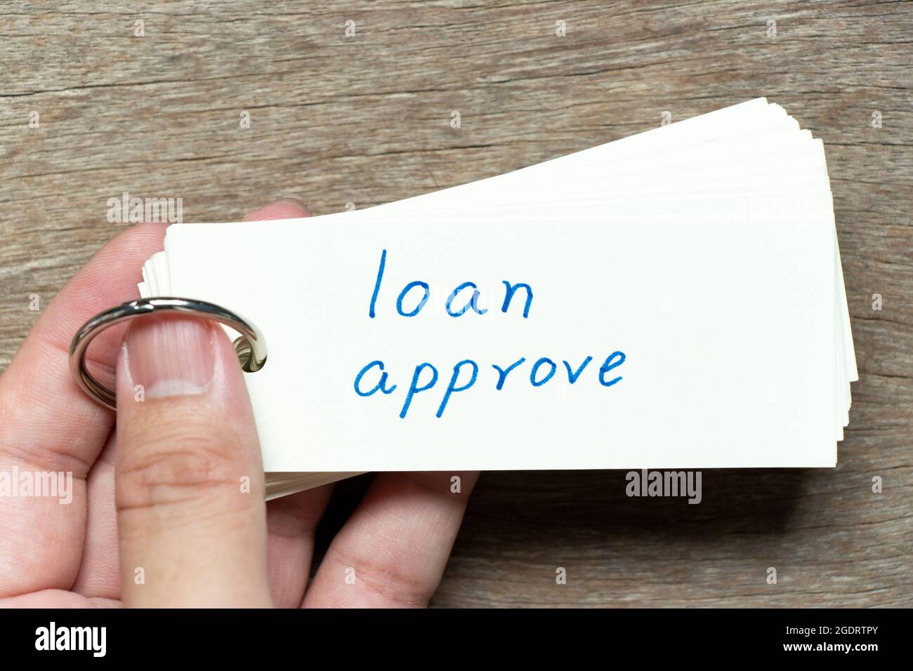 Man hold the flash card with handwriting word loan approve on wood ...