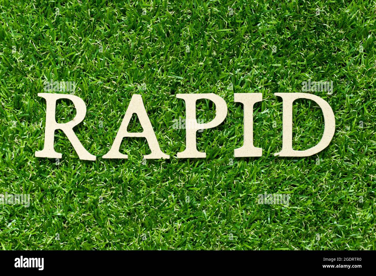 Wood letter in word rapid on green grass background Stock Photo - Alamy