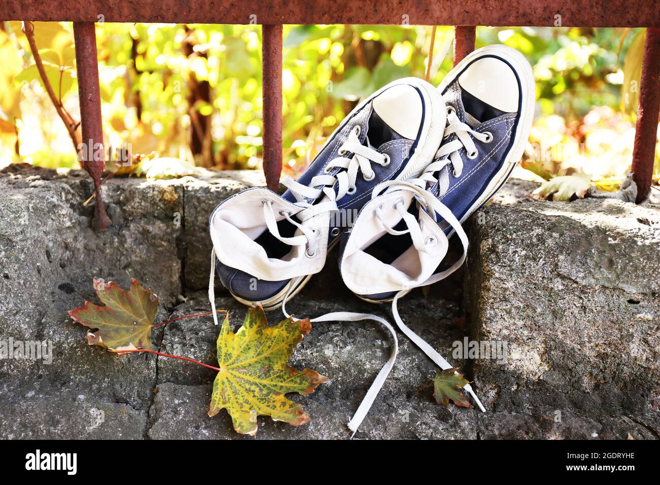 Sneakers near metal fence Stock Photo - Alamy