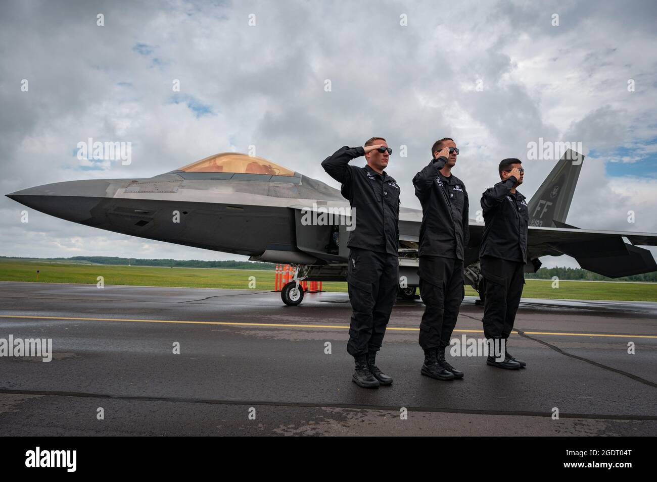 Members of the F-22 Demo Team salute the U.S. flag during the National ...
