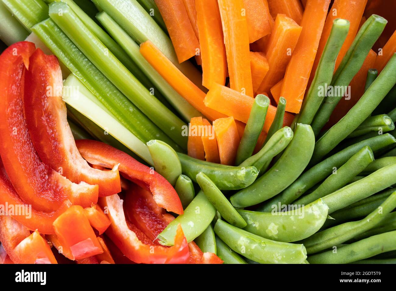A close up rainbow of healthy fresh organic vegetables cut up into ...