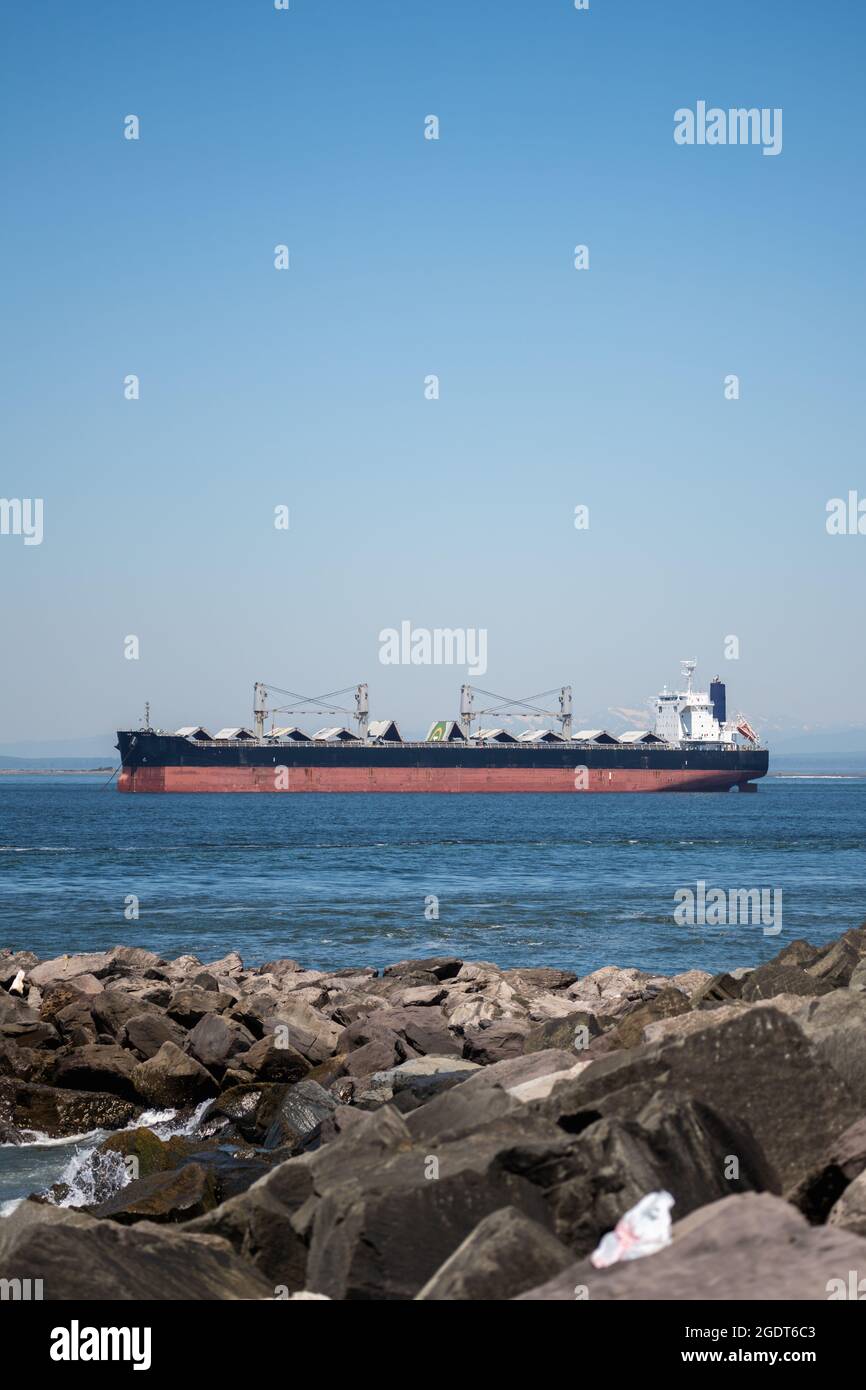 cargo ship going out to sea from the bay Stock Photo - Alamy