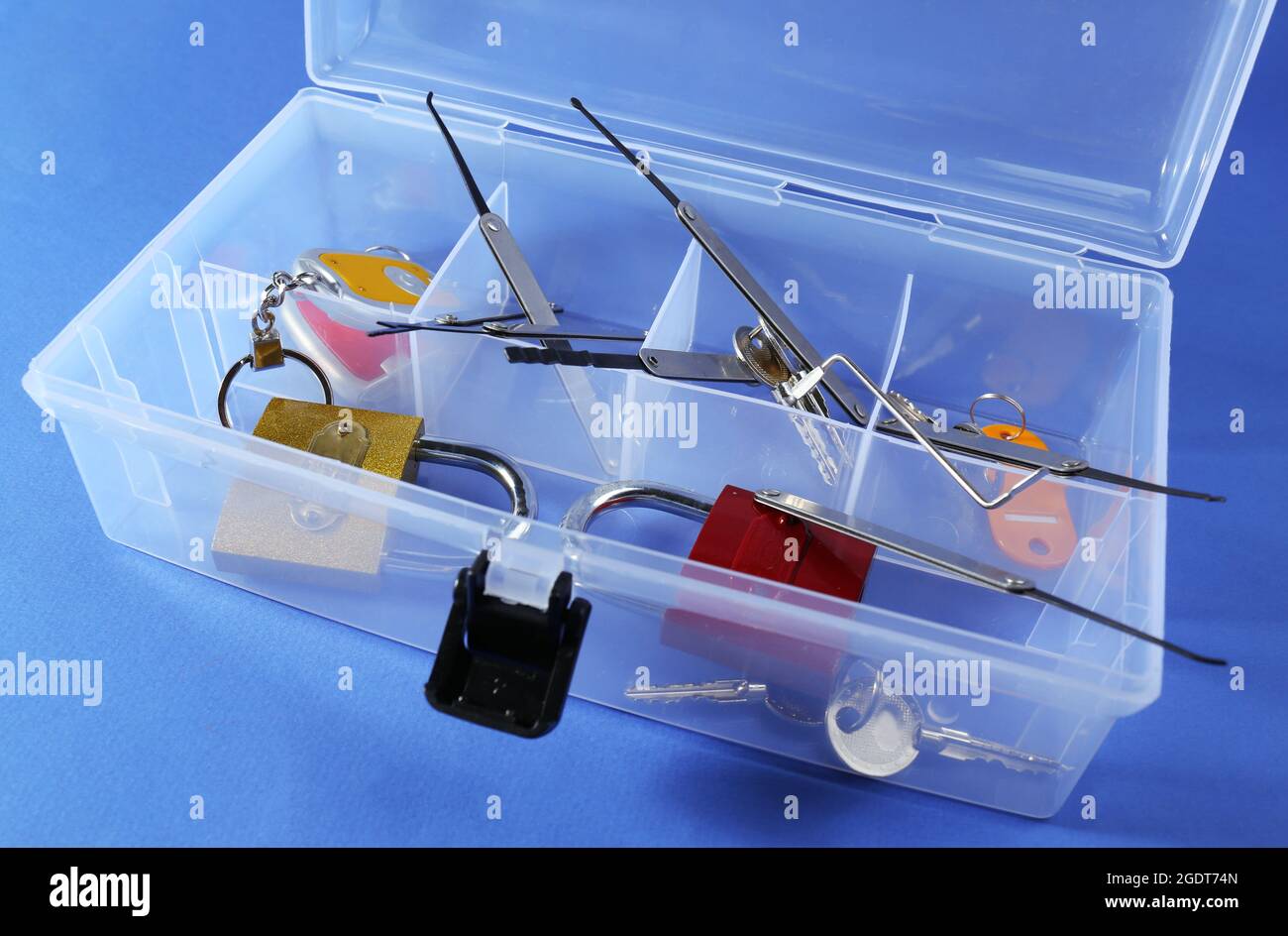 Set of keys, lock picks in box on blue background Stock Photo - Alamy