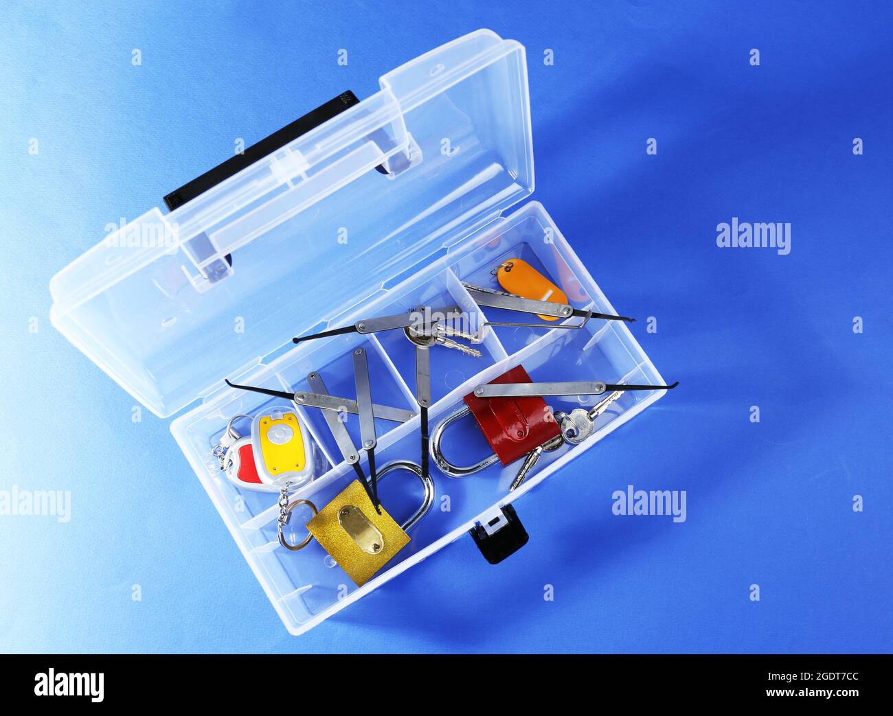 Set of keys, lock picks in box on blue background Stock Photo - Alamy