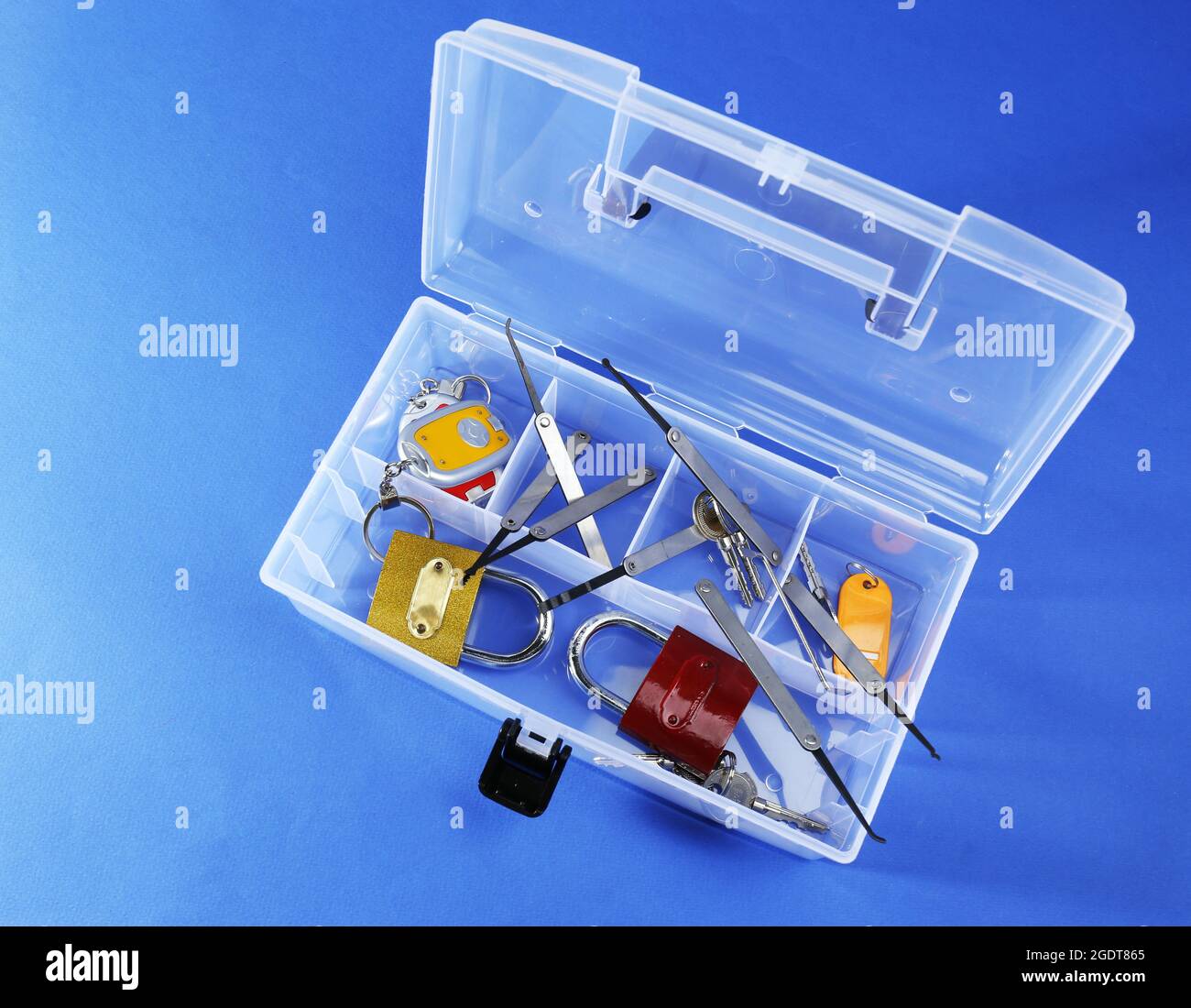 Set of keys, lock picks in box on blue background Stock Photo - Alamy