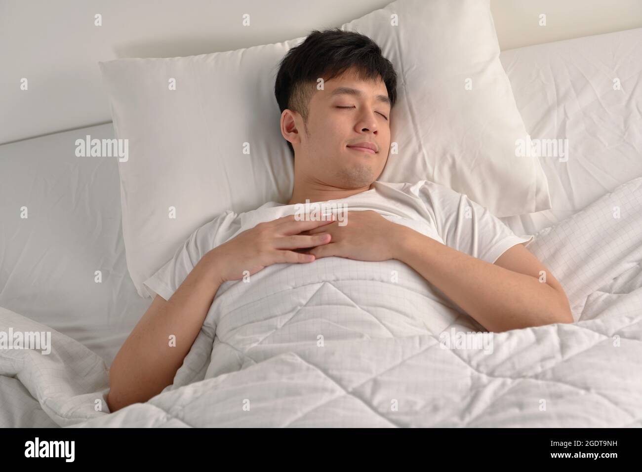 Handsome Young Asian man sleeping in bed Stock Photo - Alamy