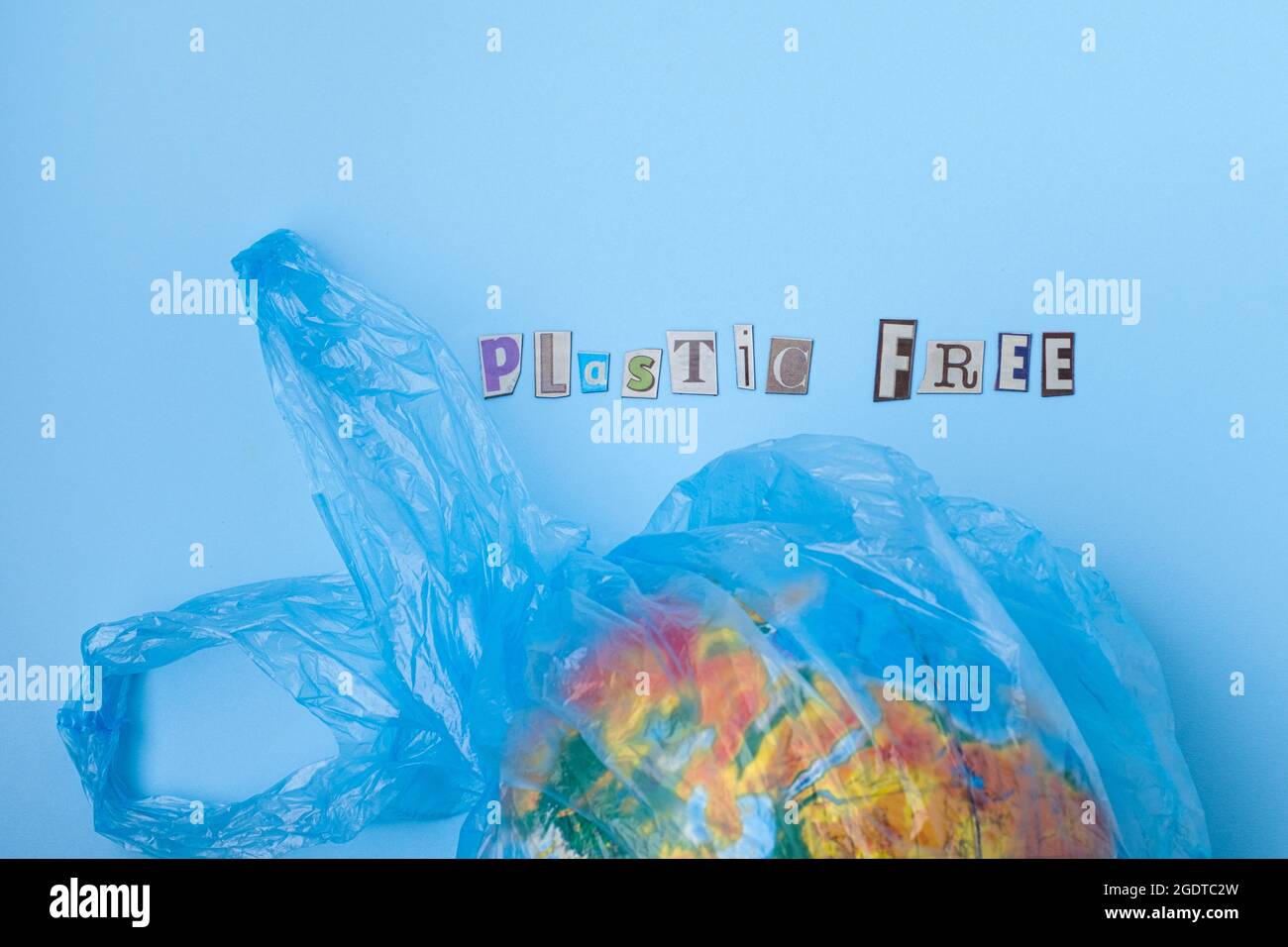 Plastic free words cut out of magazines. Flat lay, on a blue background ...