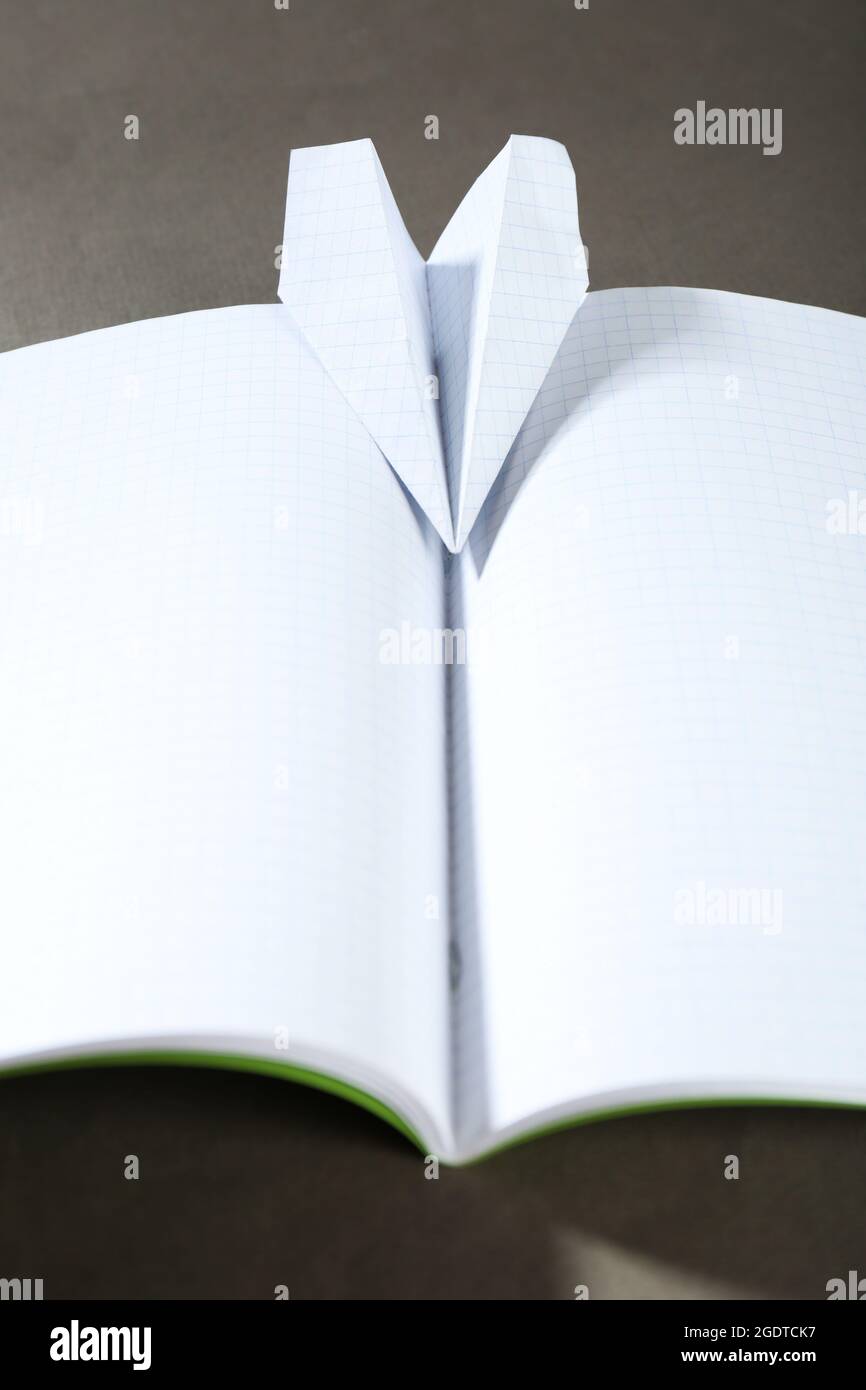 Origami airplane on notebook, close up Stock Photo - Alamy