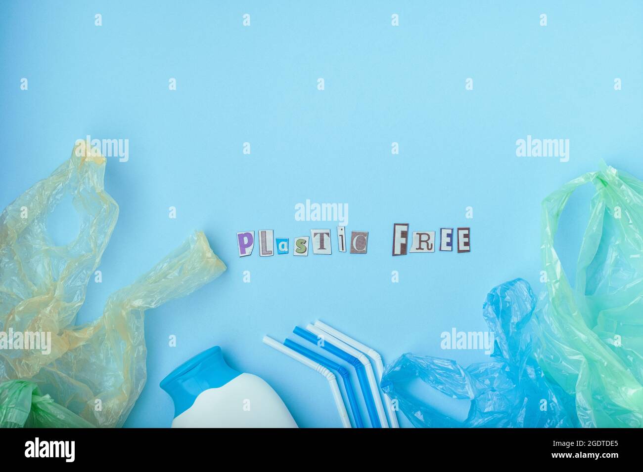 Plastic free words cut out of magazines. Flat lay, on a blue background ...