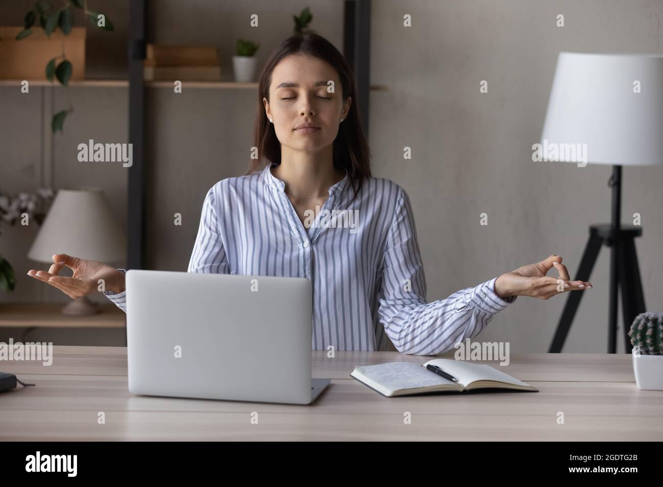 Calm woman meditate at workplace at desk Stock Photo - Alamy