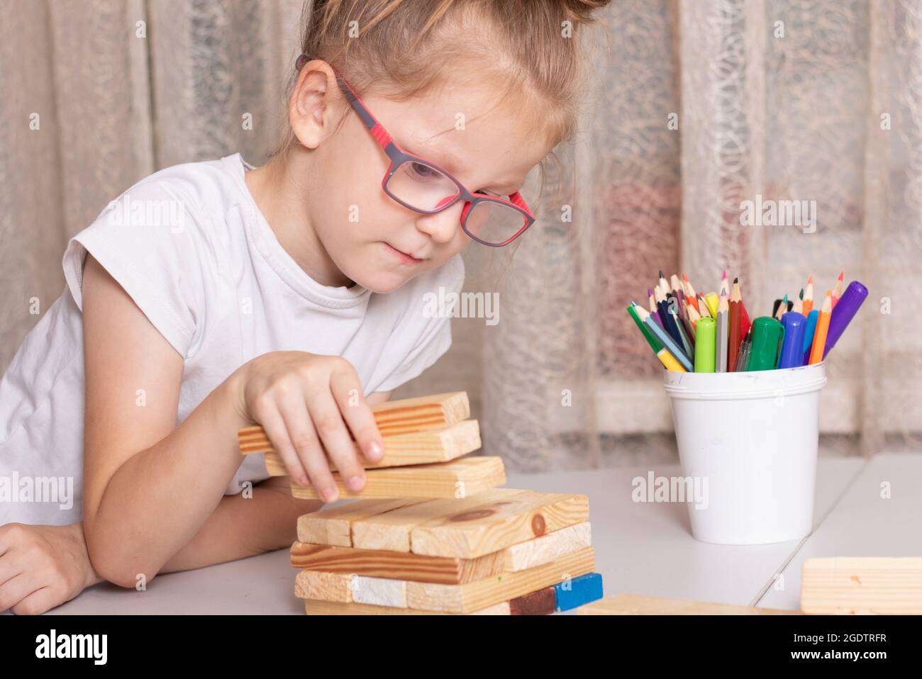 Girl playing with blocks at home, home education Stock Photo - Alamy