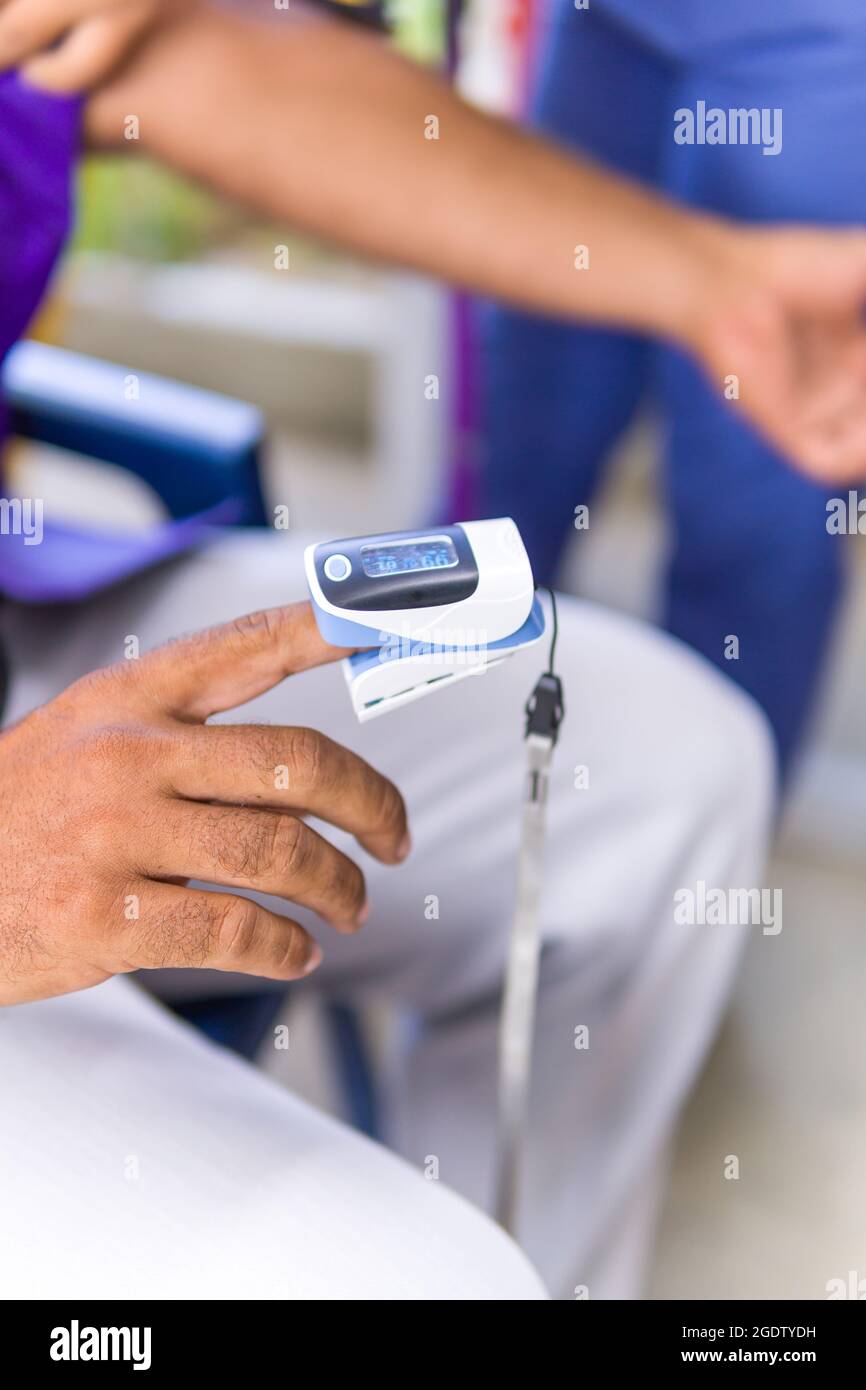 A patient's hand with a pulse oximeter to measure pulse rate and oxygen ...