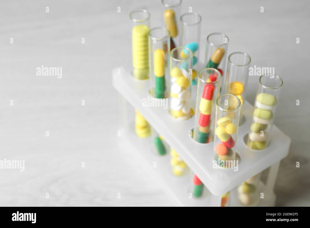 Different color drugs in test tubes, on wooden table background Stock ...