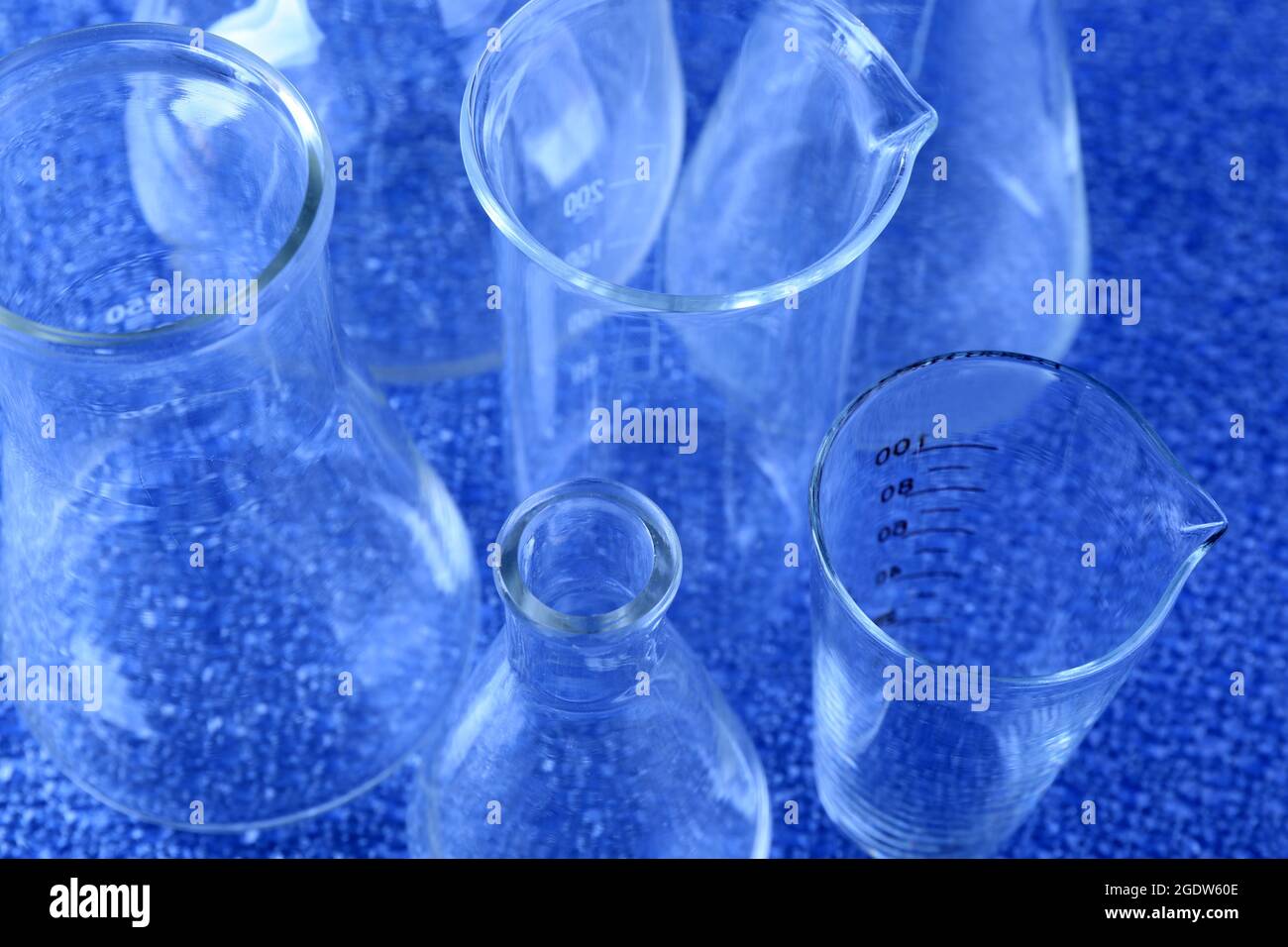 Different laboratory glassware on color background Stock Photo - Alamy