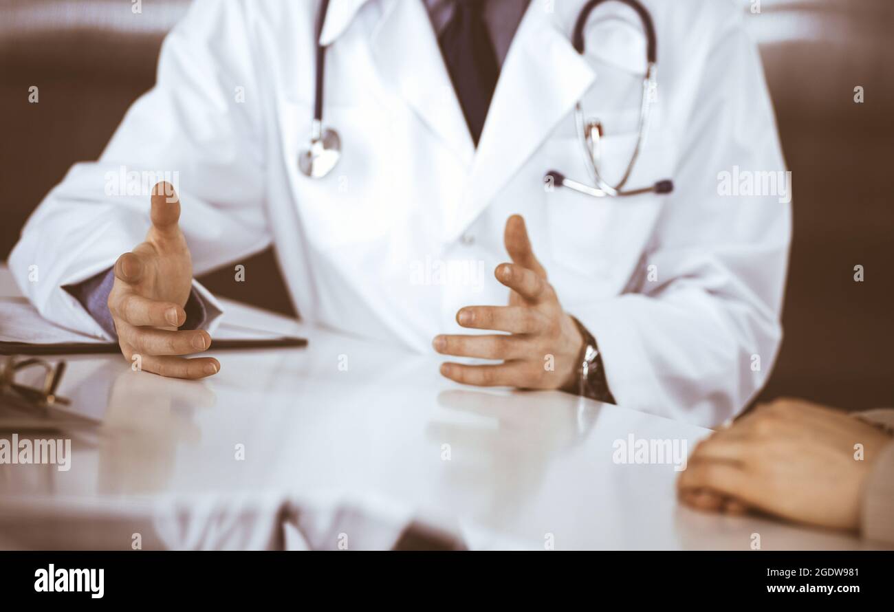 Unknown male doctor and patient woman discussing something while ...