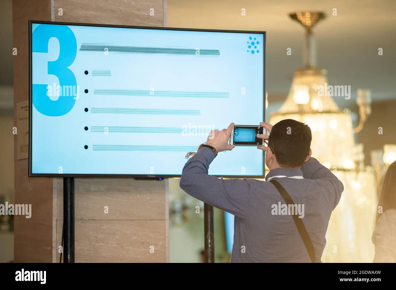Man photographs information from a monitor screen using a smartphone ...