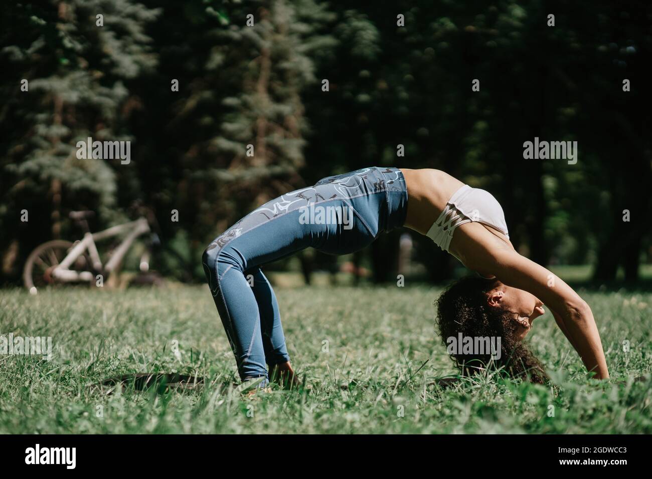 athletic young woman performing a bridge exercise outdoors Stock Photo ...