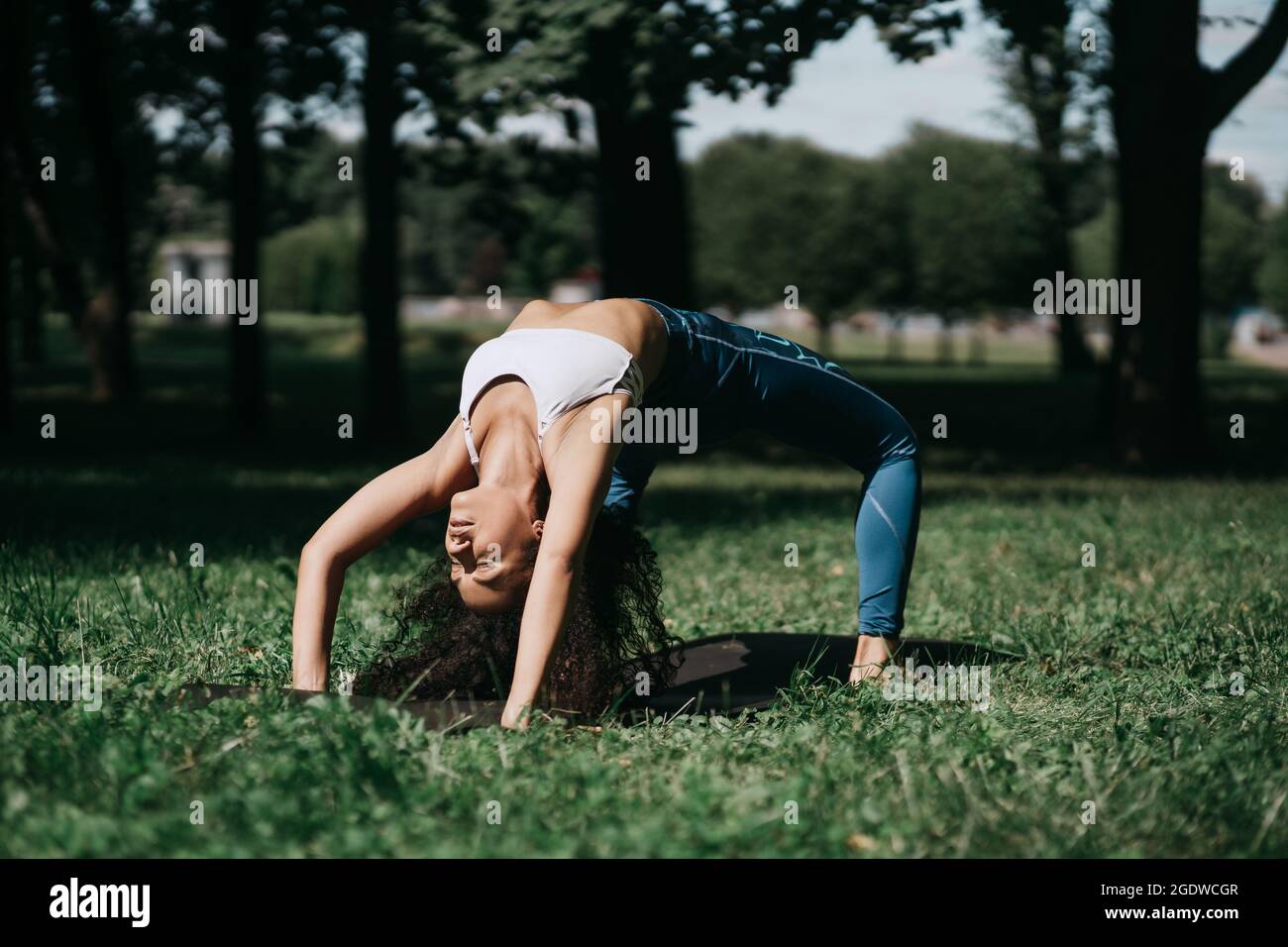 athletic young woman performing a bridge exercise outdoors Stock Photo ...