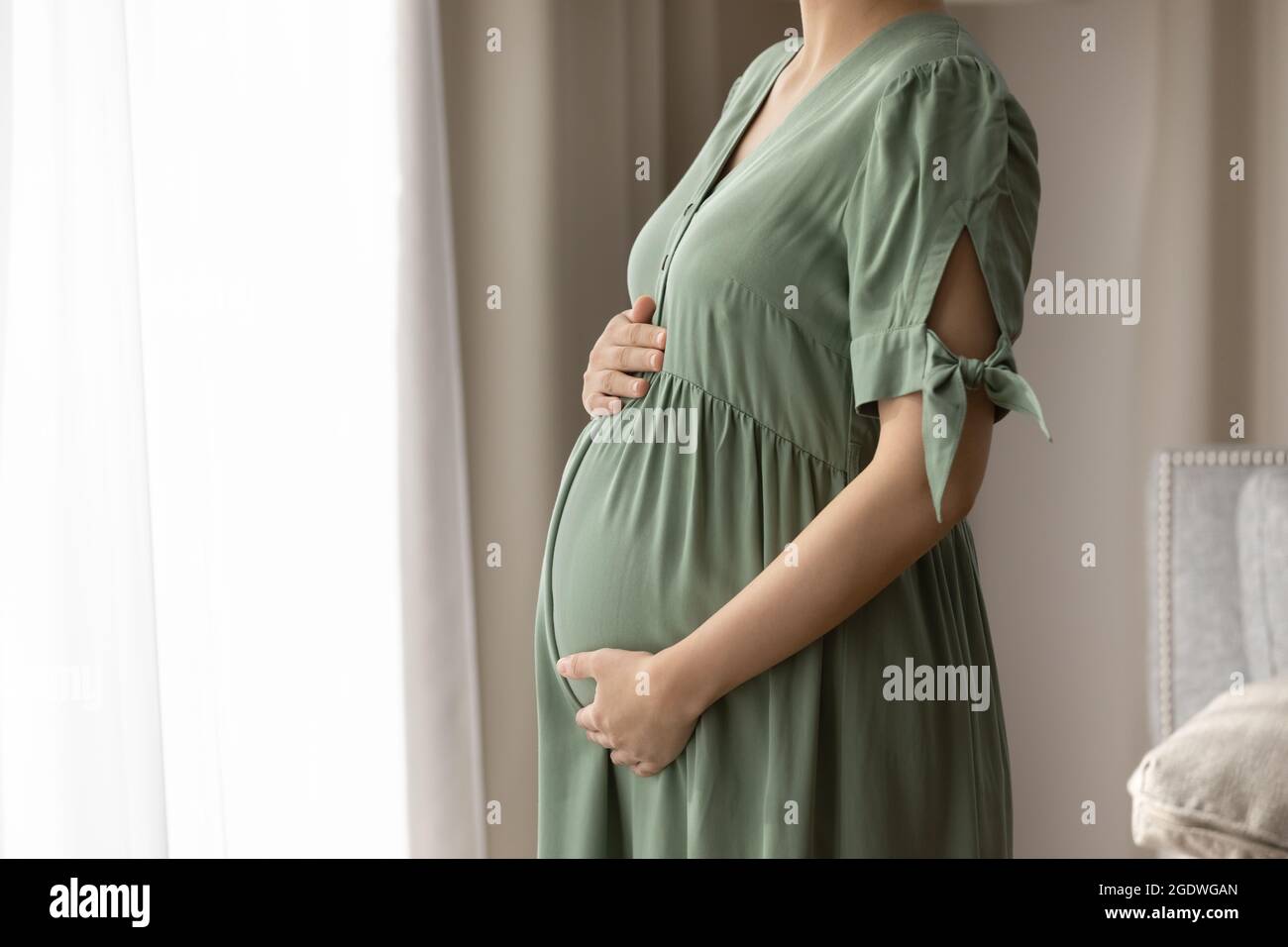 Expectant mother wearing dress for pregnant, holding big baby bump ...