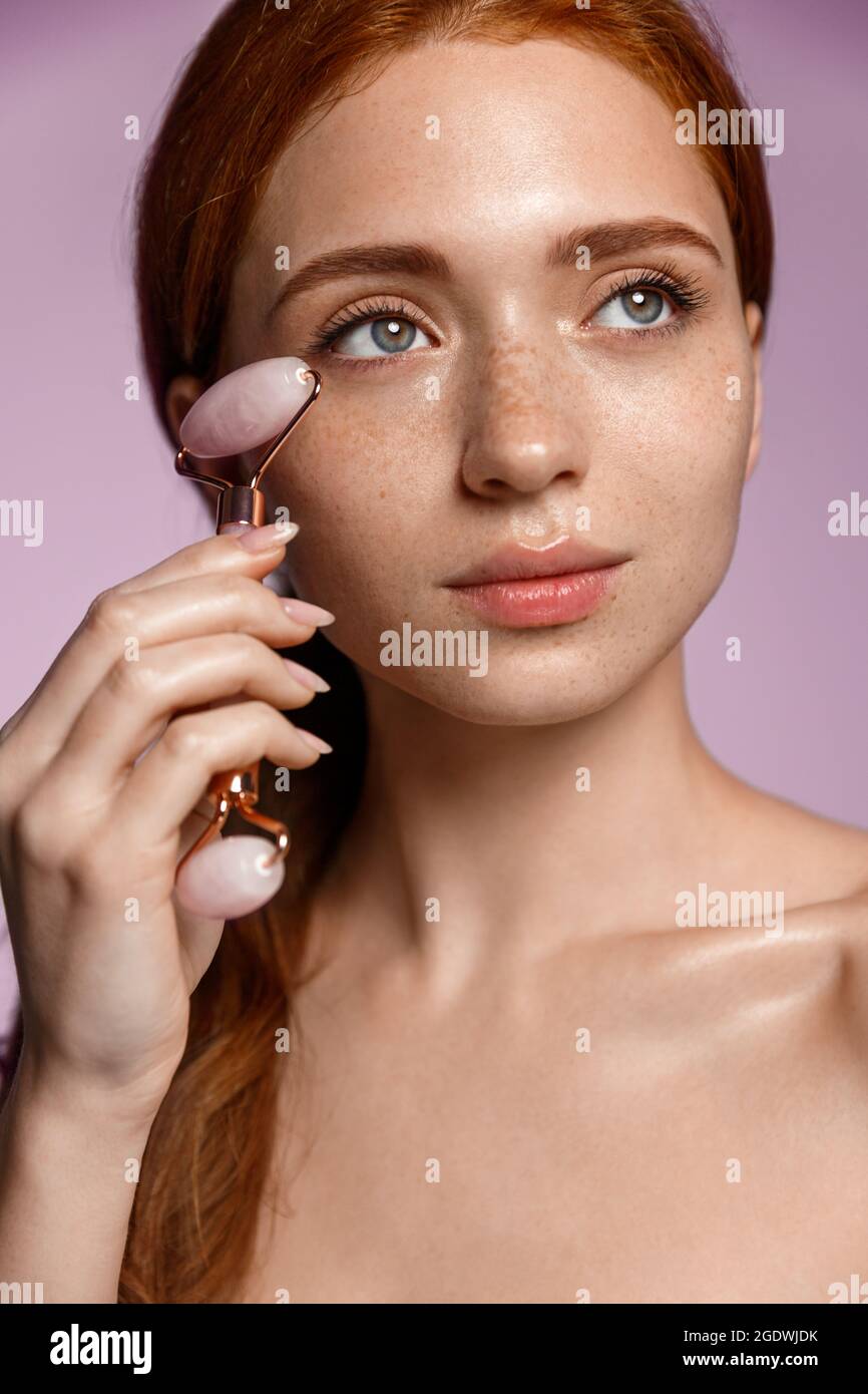 Natural girl with red hair and freckles doing facial spa tcm massage ...