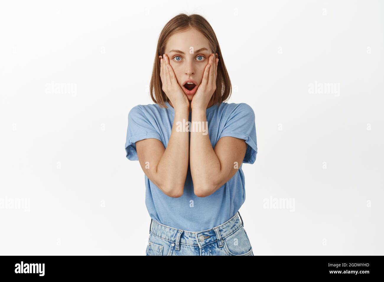 Shocked blond girl open mouth, staring startled at smth terrible ...