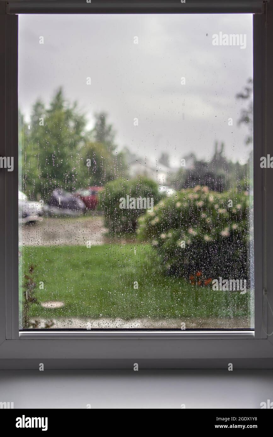 Rainy day view from the window, raindrops on glass, blurred cloudy ...