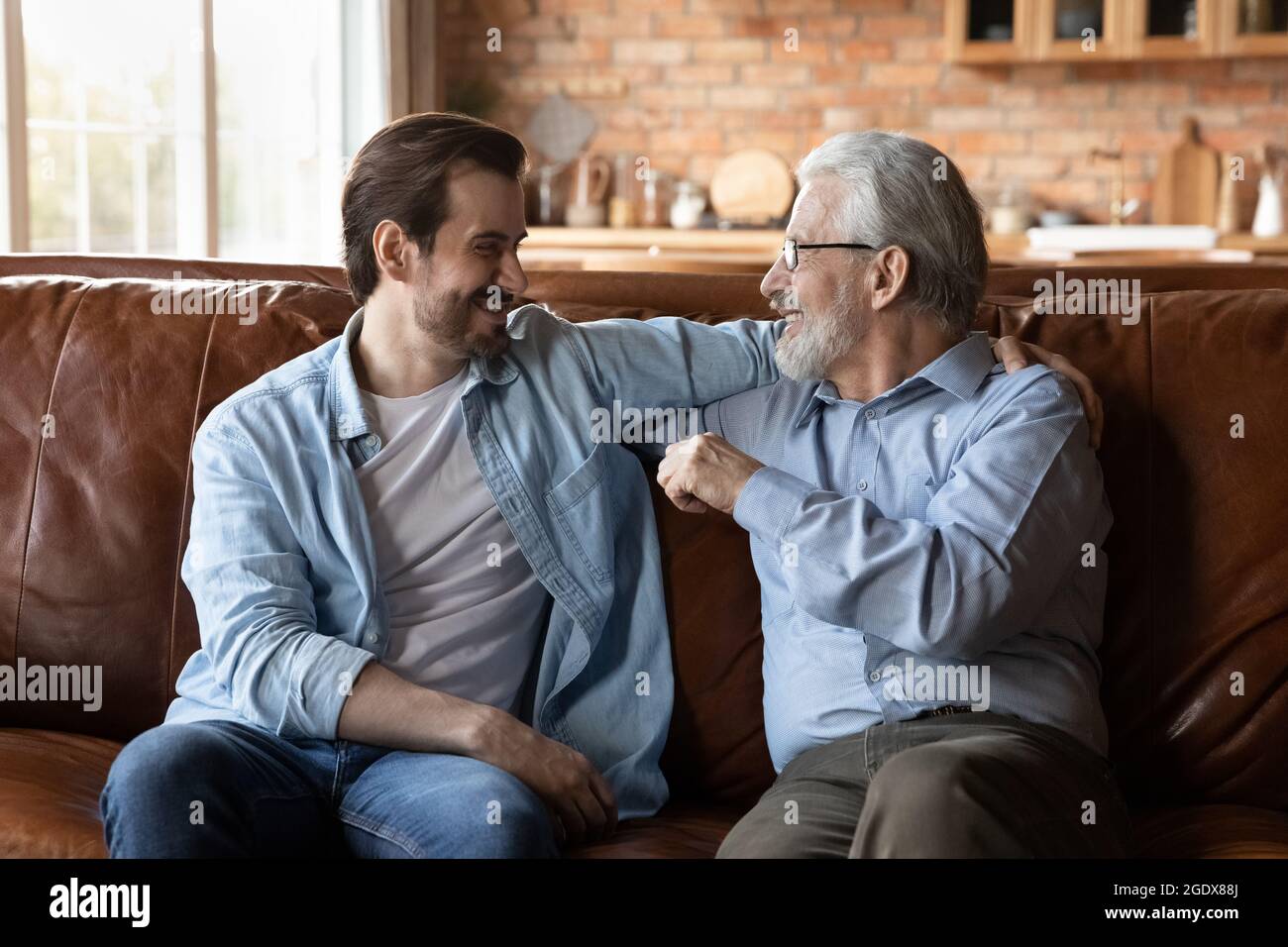 Happy older father and adult son relax at home Stock Photo - Alamy