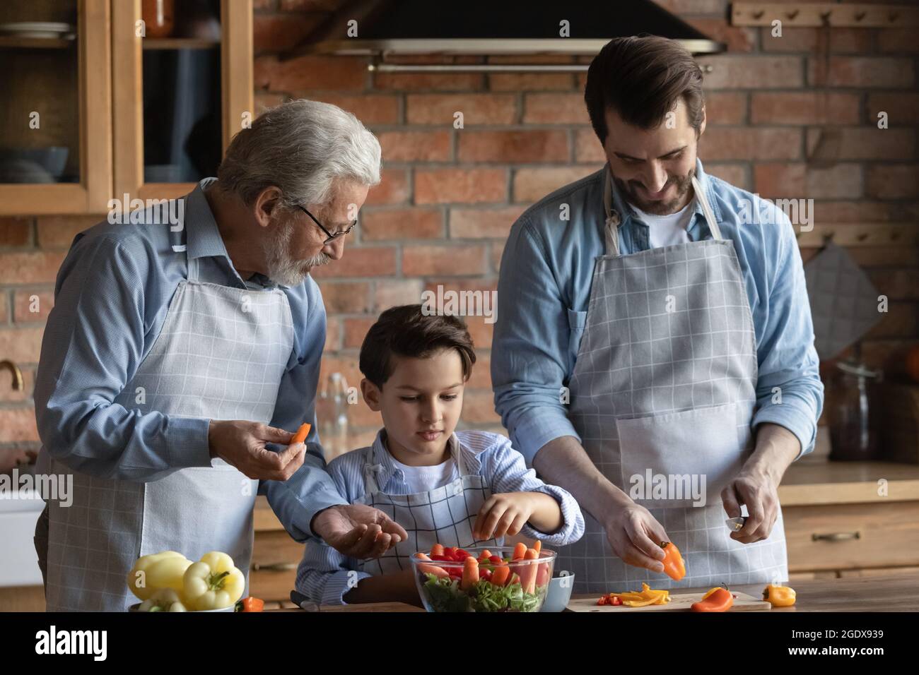 Happy three generations of men cooking together Stock Photo - Alamy