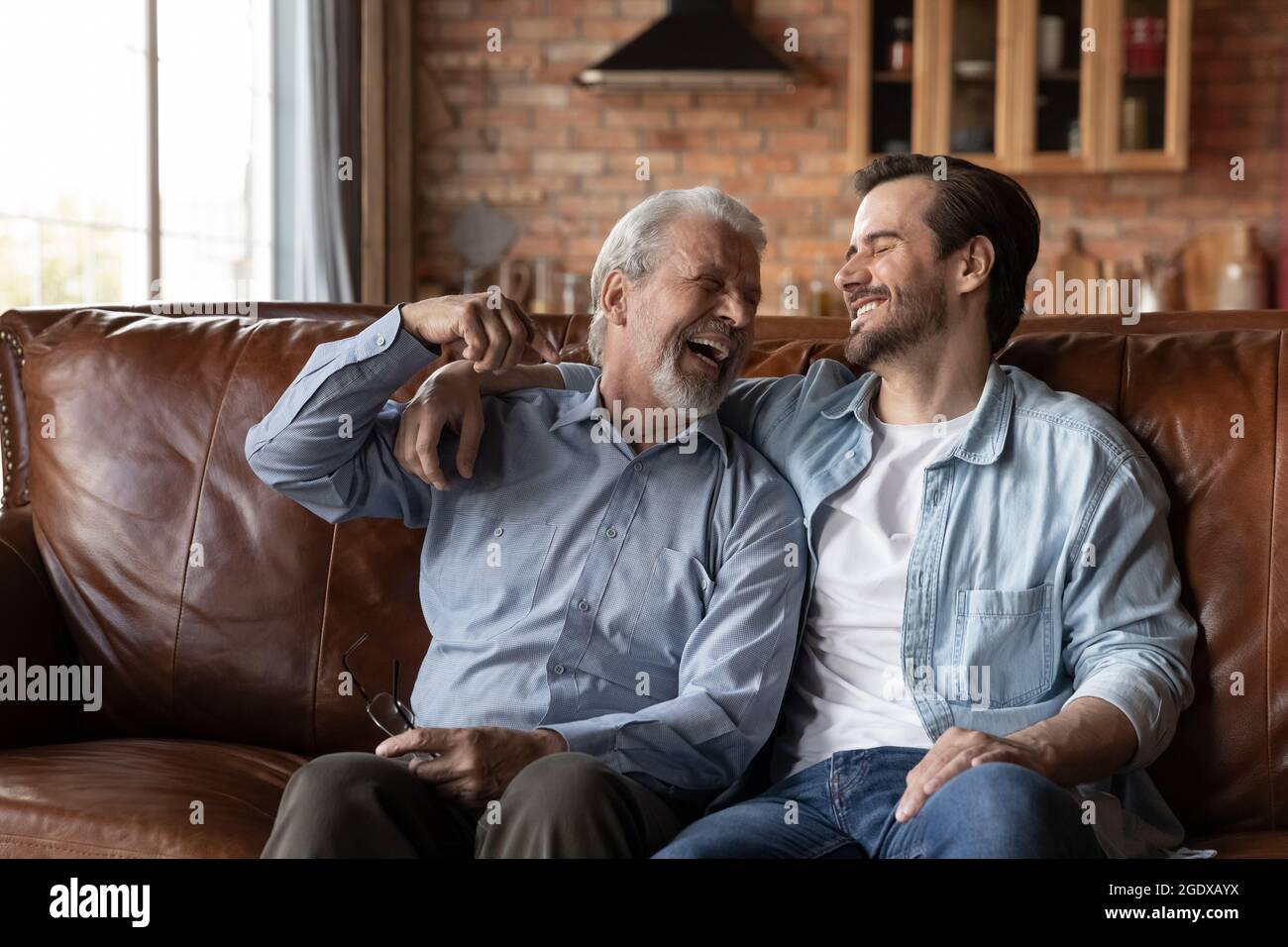Smiling old Caucasian father and adult son laugh relaxing Stock Photo ...