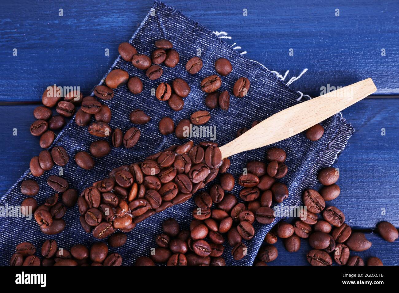 Wooden sticky spoons with coffee beans and crystals on blue wooden ...