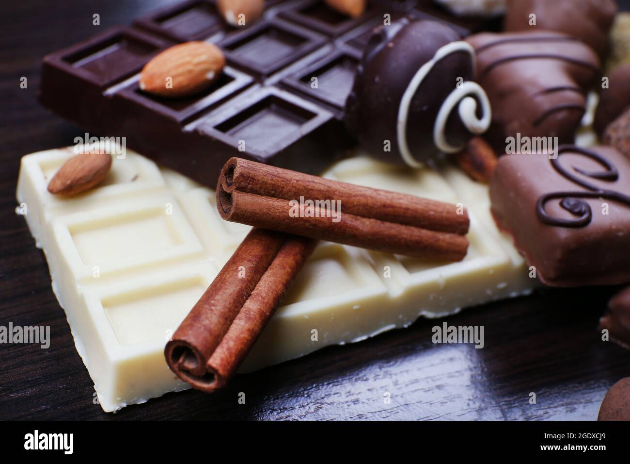 Bars of white and bitter chocolates with candies, cinnamon stick and ...