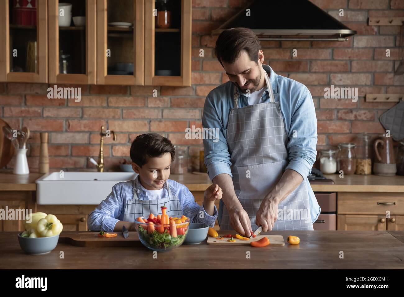 Smiling young dad and small son cooking together Stock Photo - Alamy