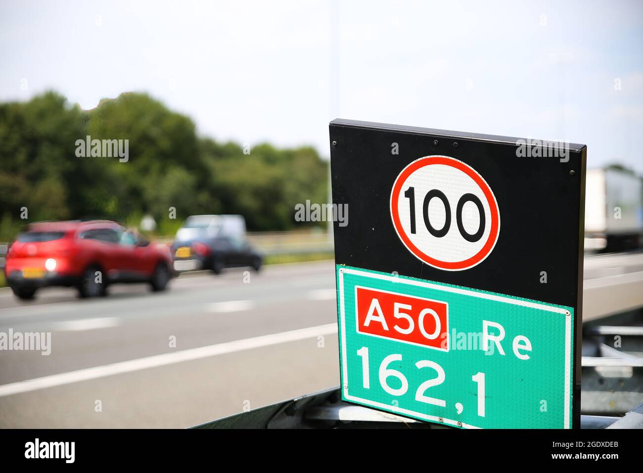 Closeup of 100 speed limit sign at dutch highway, blurred cars ...