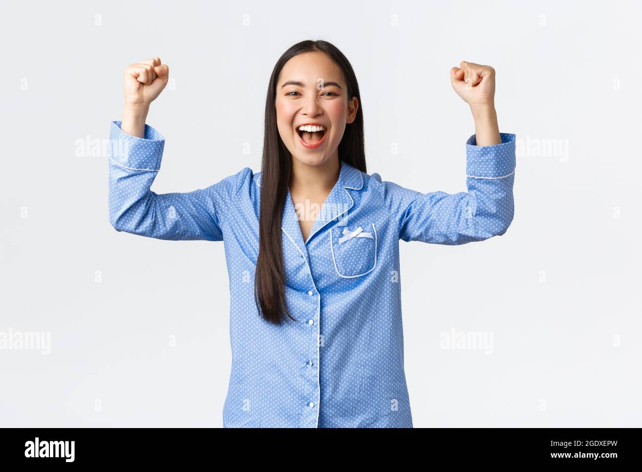 Triumphing empowered asian girl feeling lucky and upbeat, raising hands ...