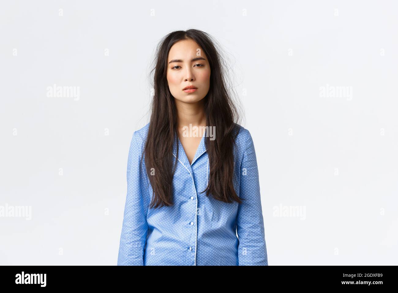 Exhausted asian woman with messy hair after lying in bed, wearing ...