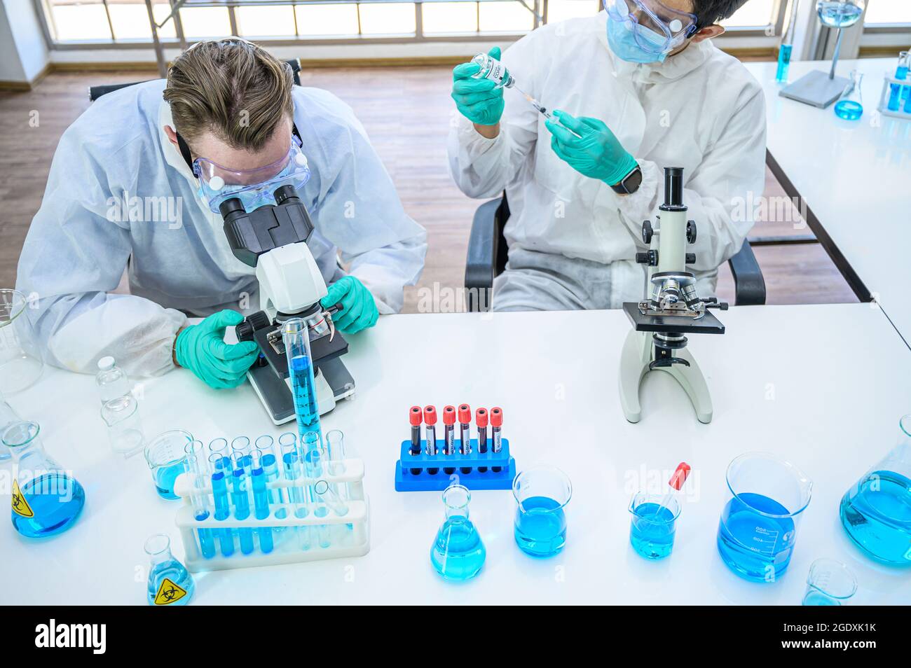 Couple male scientist wearing protection suit working with Microscope ...