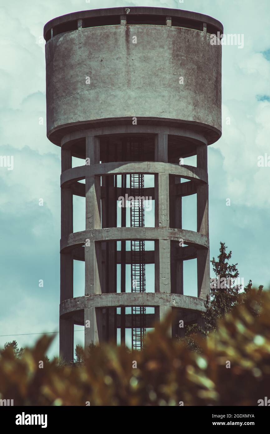 A selective of a tall water tower in the greenery Stock Photo - Alamy