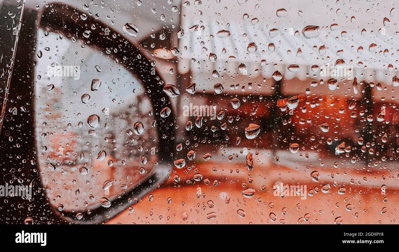 A closeup of the crystal clear rain droplets on the transparent glass ...