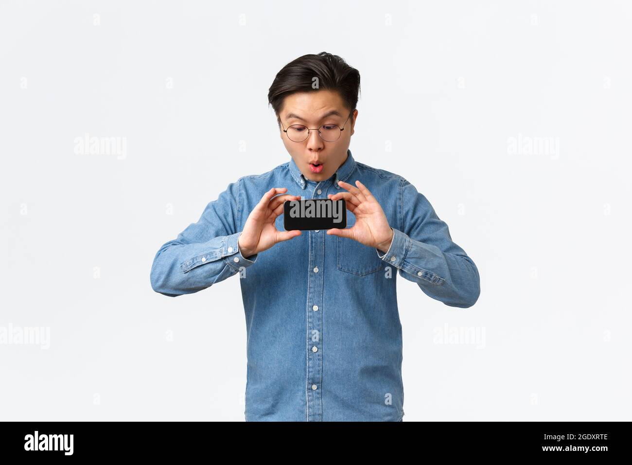 Impressed asian guy react to new movie trailer, showing friends mobile ...