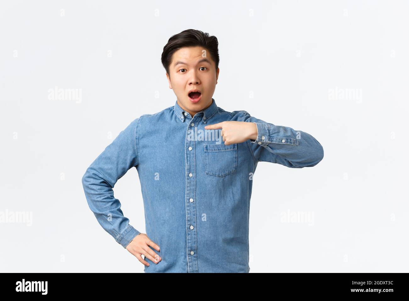 Surprised and questioned asian handsome guy in blue shirt, pointing at ...