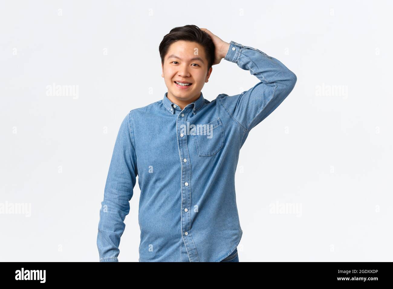 Modest smiling asian man, blushing as making good deed, scratching head ...