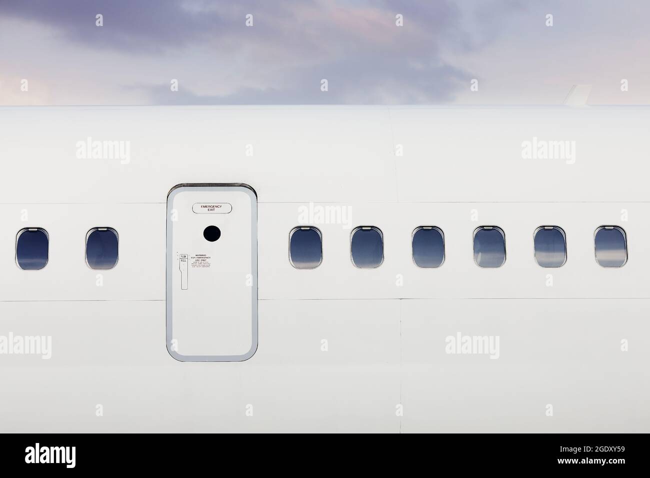 Fuselage of airplane with door and windows. Plane against moody sky ...