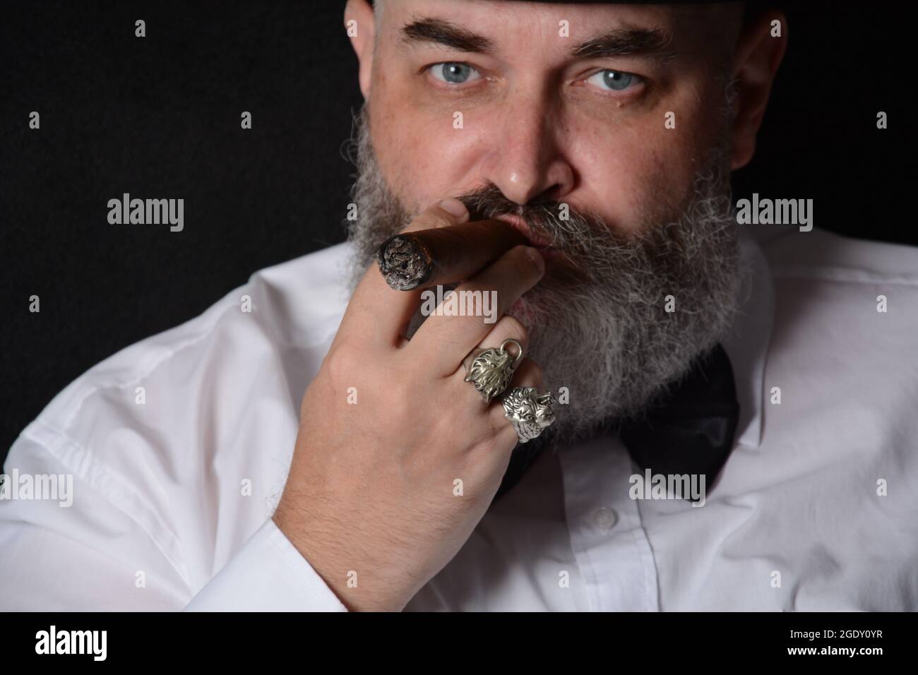 Portrait of a man with a cigar and a beard in a dark room Stock Photo ...