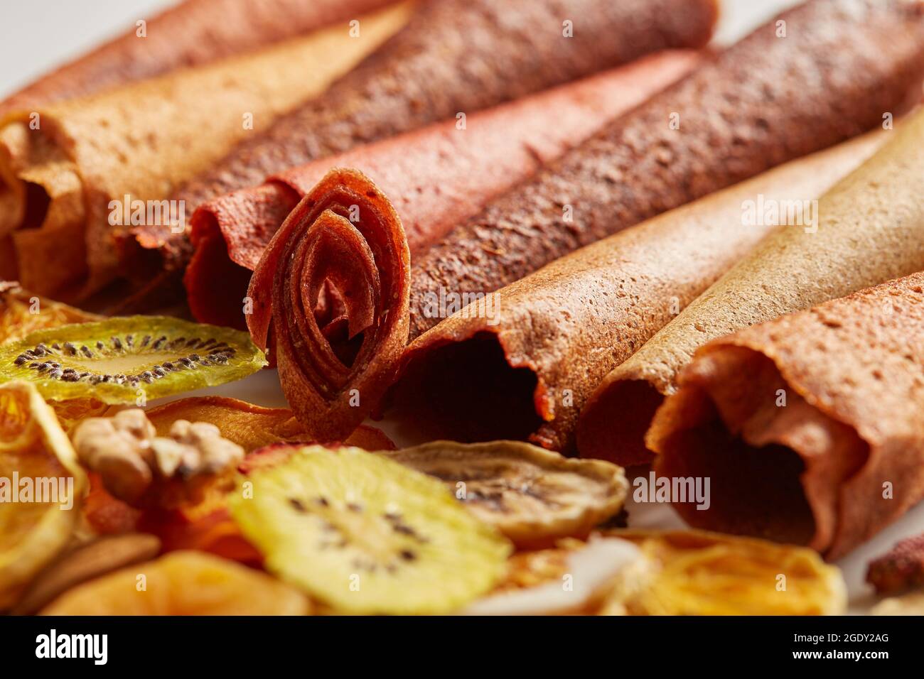 Close up of neatly stacked fruit lozenge different colors and almonds ...
