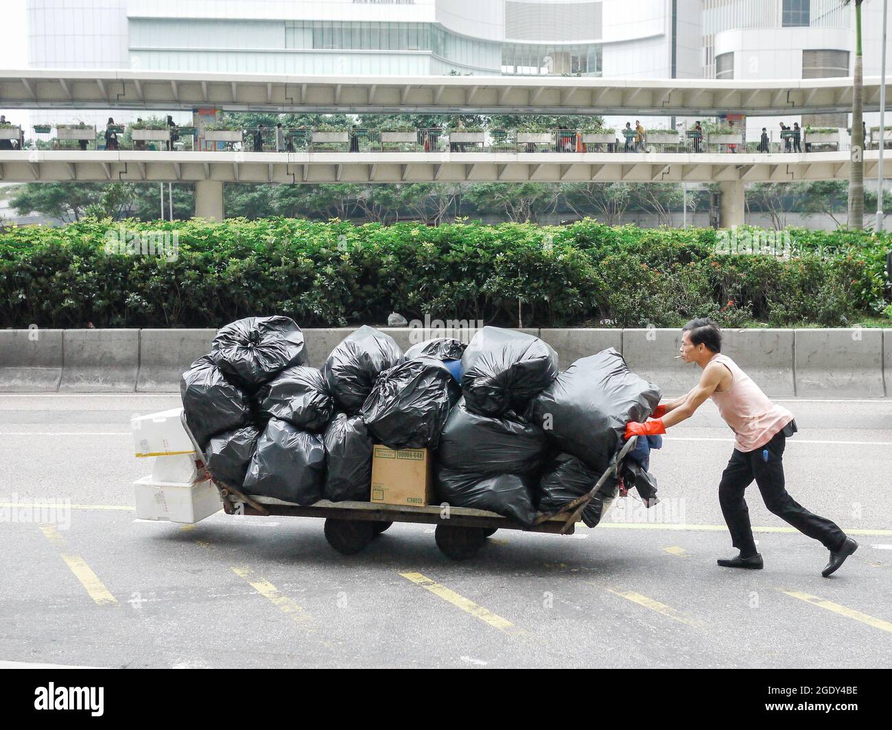 Asian man pushing trash trolley in Hong Kong, China Stock Photo - Alamy