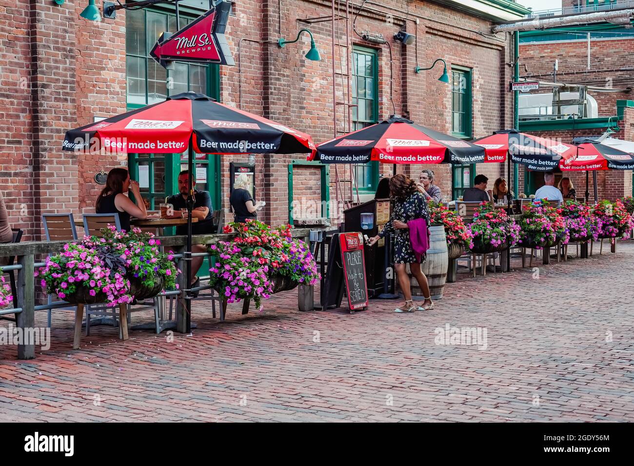 people sitting in outdoor patio at the toronto distillery district in ...