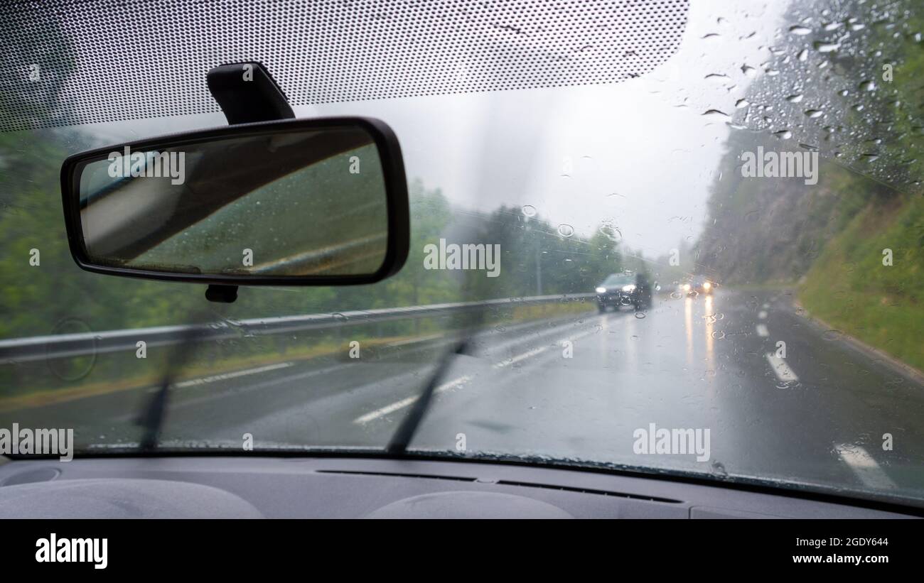 View of road traffic in rainy weather from inside an automobile ...
