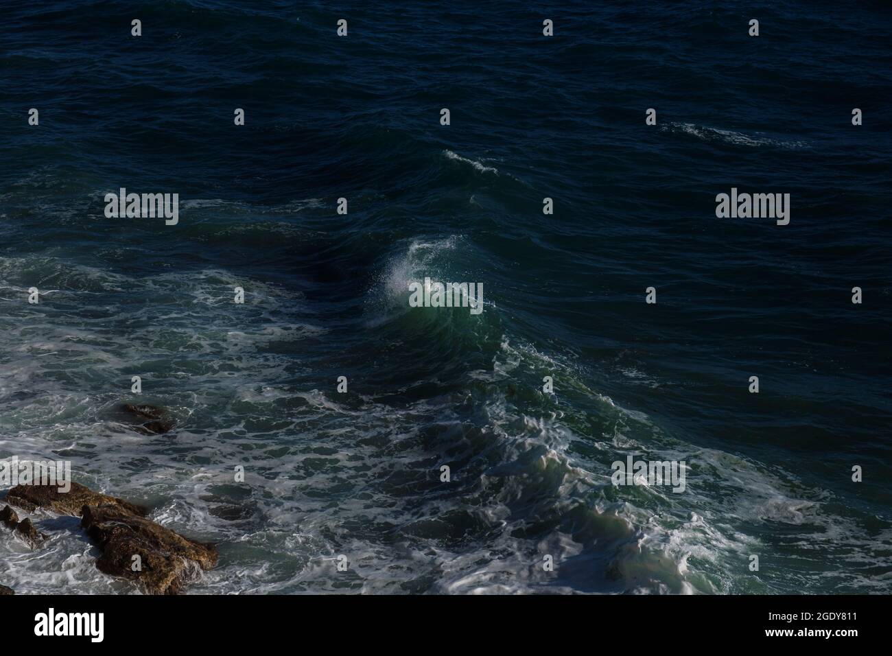 Ocean wave background breaking sea water rocky shore rough seas ...