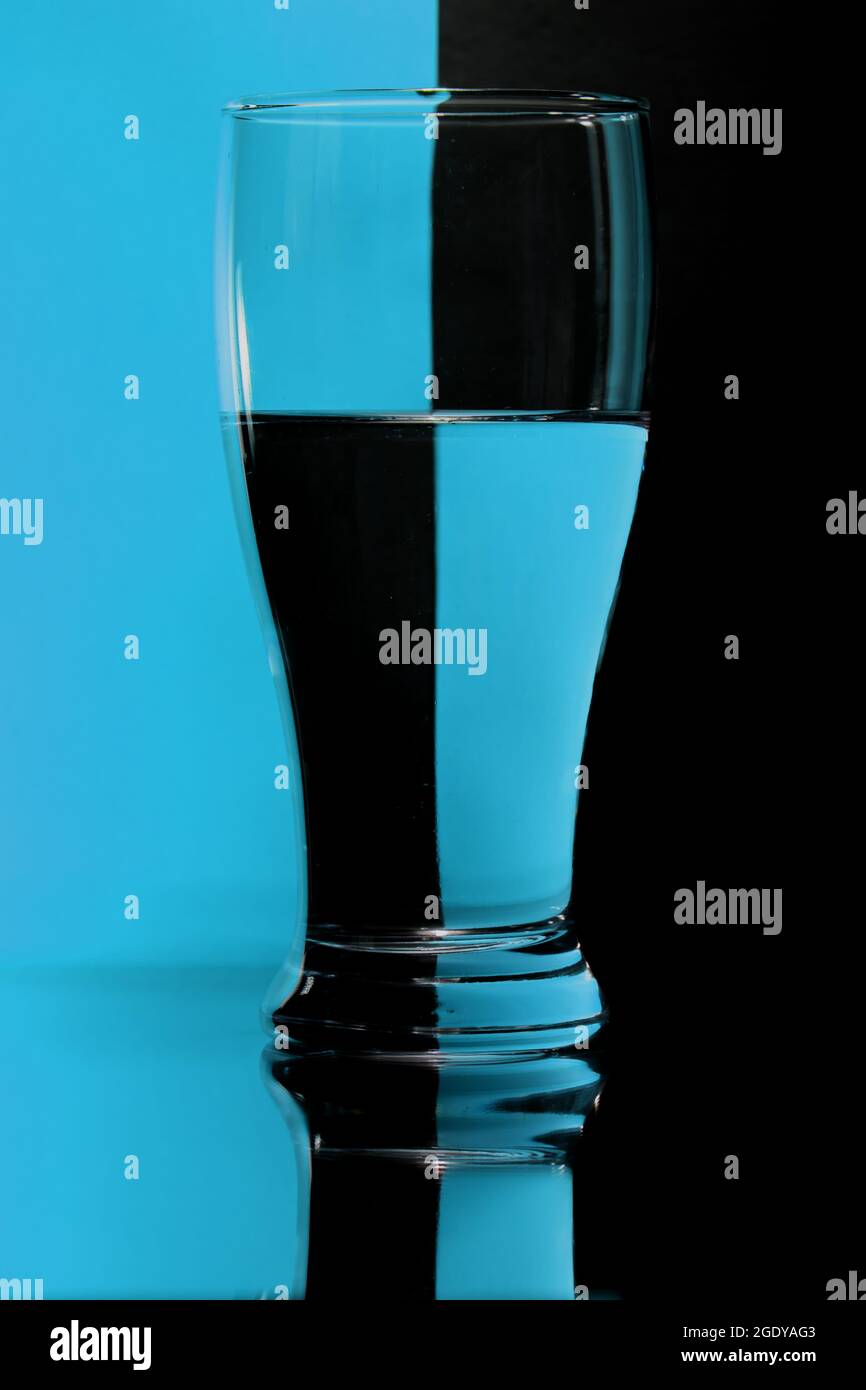 refraction of light by a glass on a blue and black squared background ...