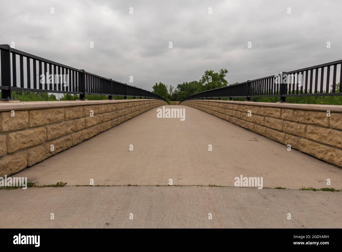 A footbridge crossing a river below Stock Photo - Alamy